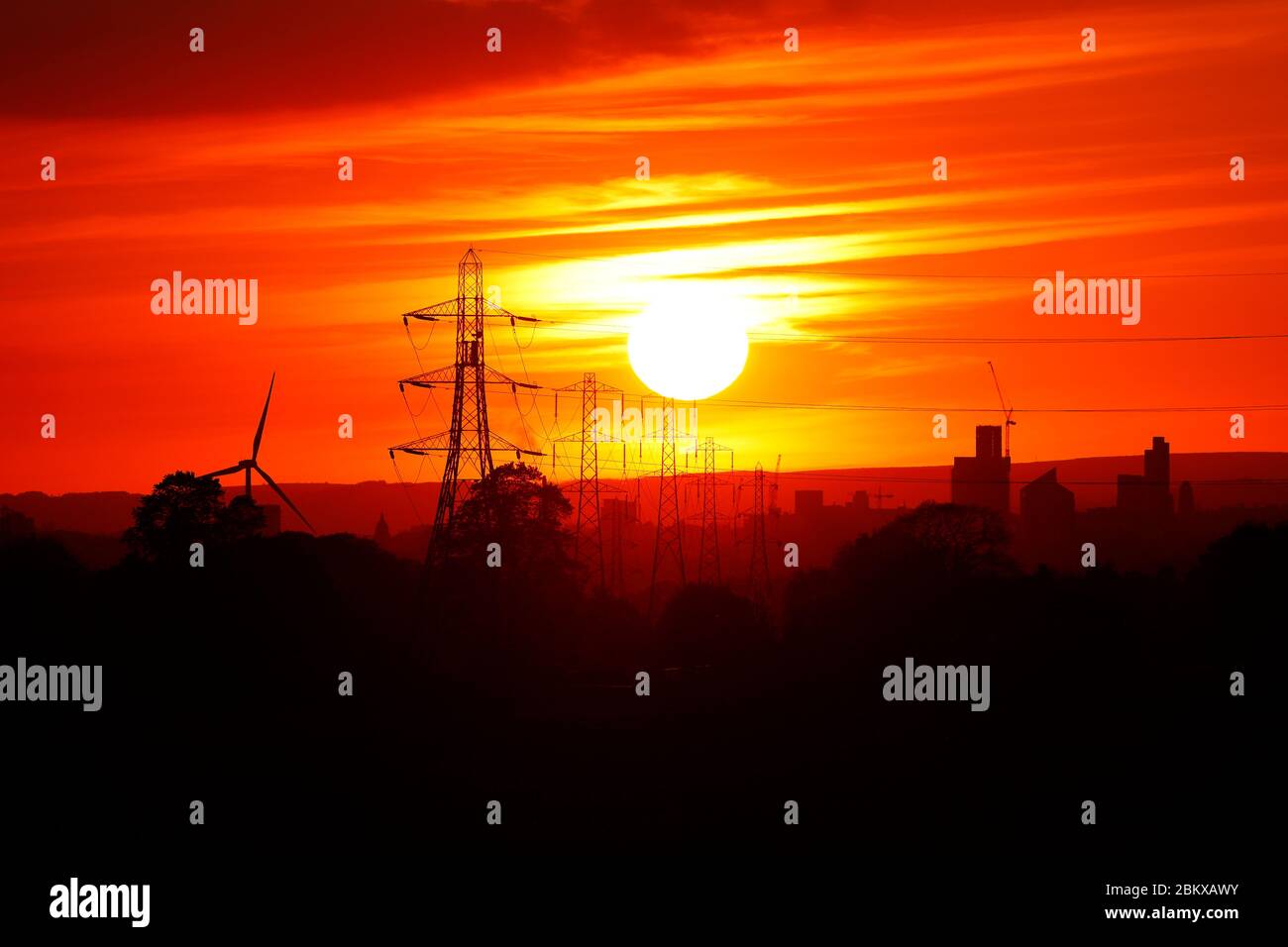 Sunset behind Leeds skyline with pylons from the National Grid at ...