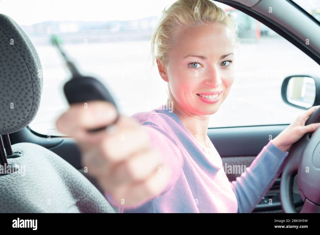 Female driver showing car keys. Young female driving happy about her ...