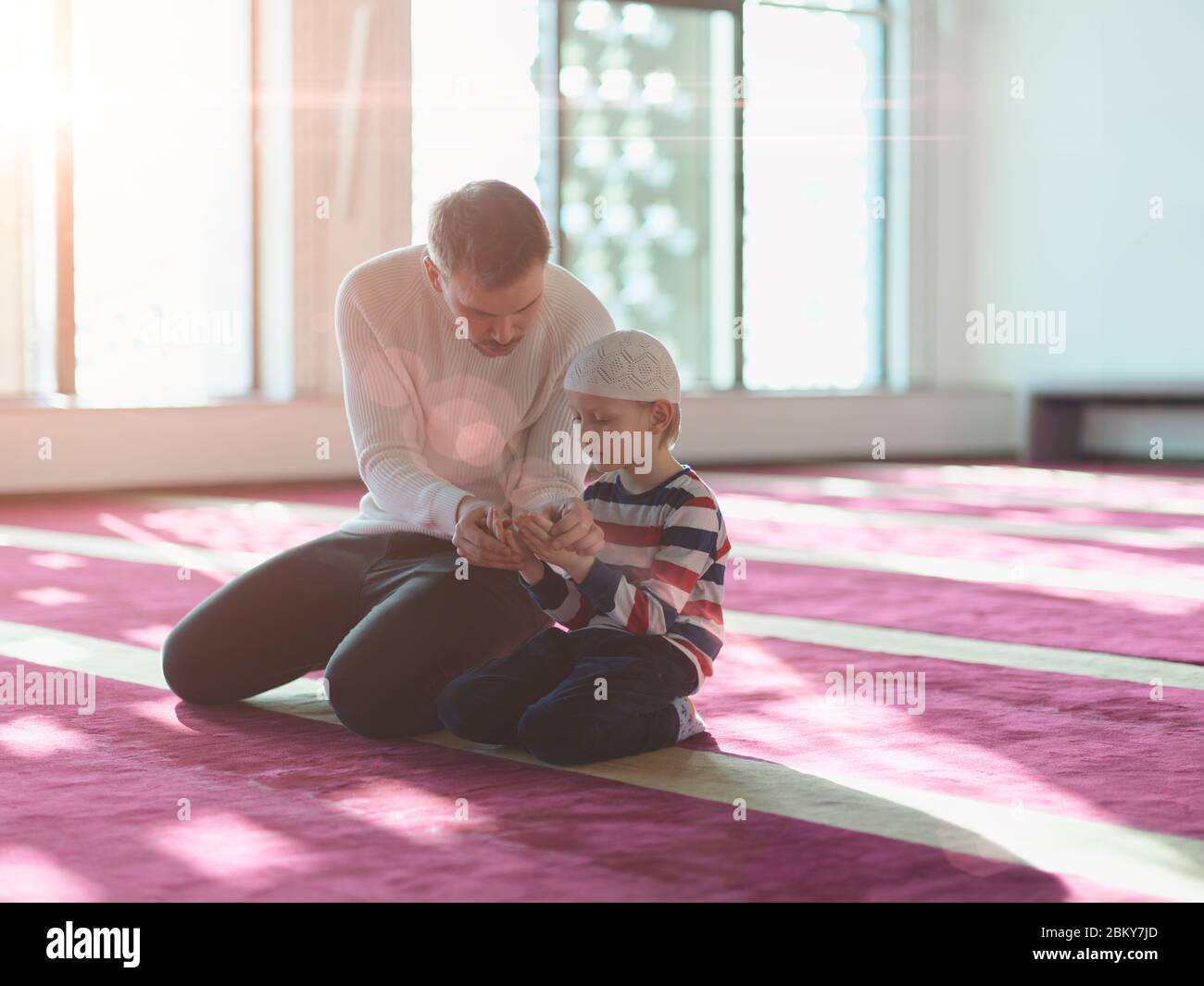 muslim prayer father and son in mosque praying and reading holly book ...