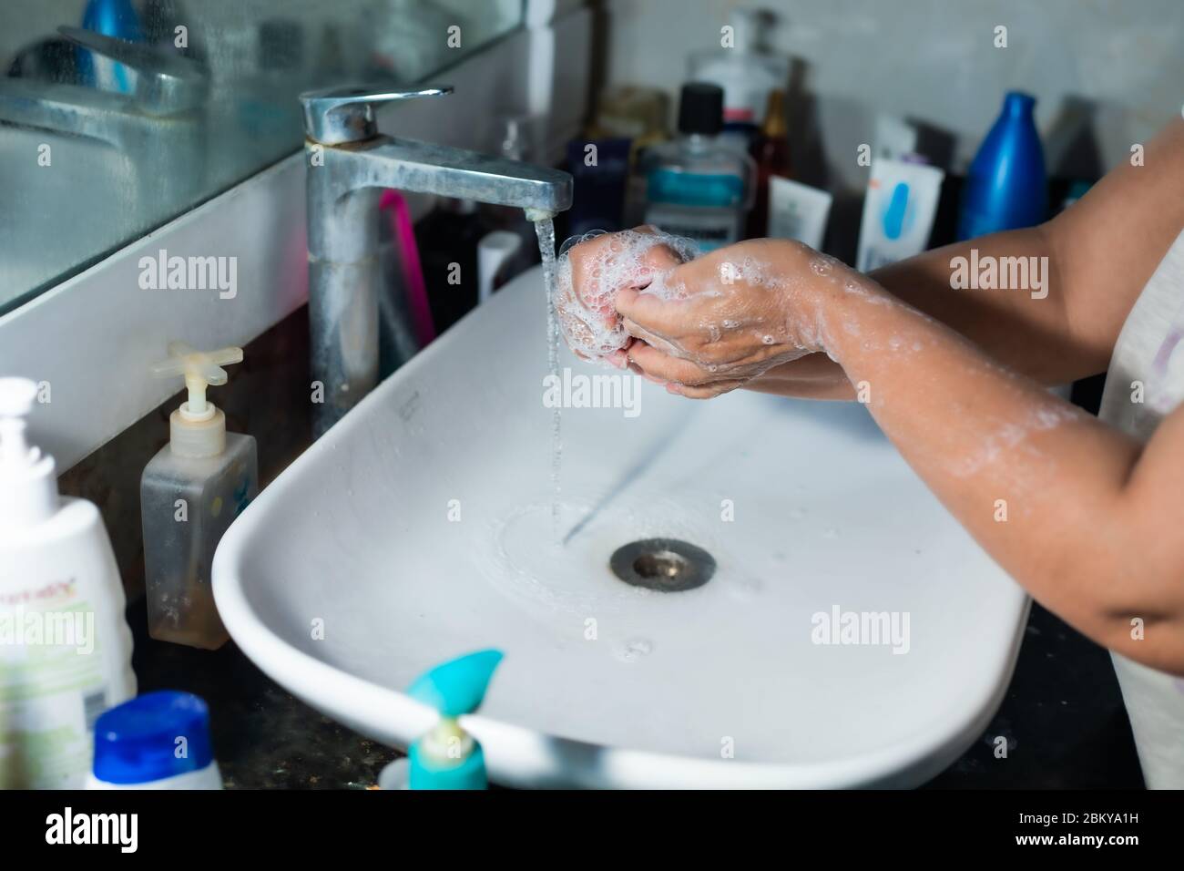 Adult washing hands and arms properly with alcohol soap under the sink ...