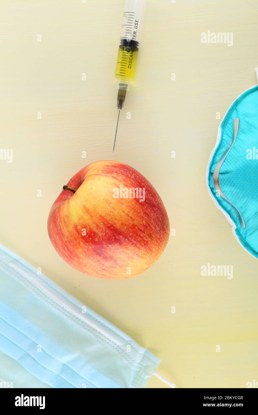 Chemical additives in food or genetically modified fruit concept. Red ...