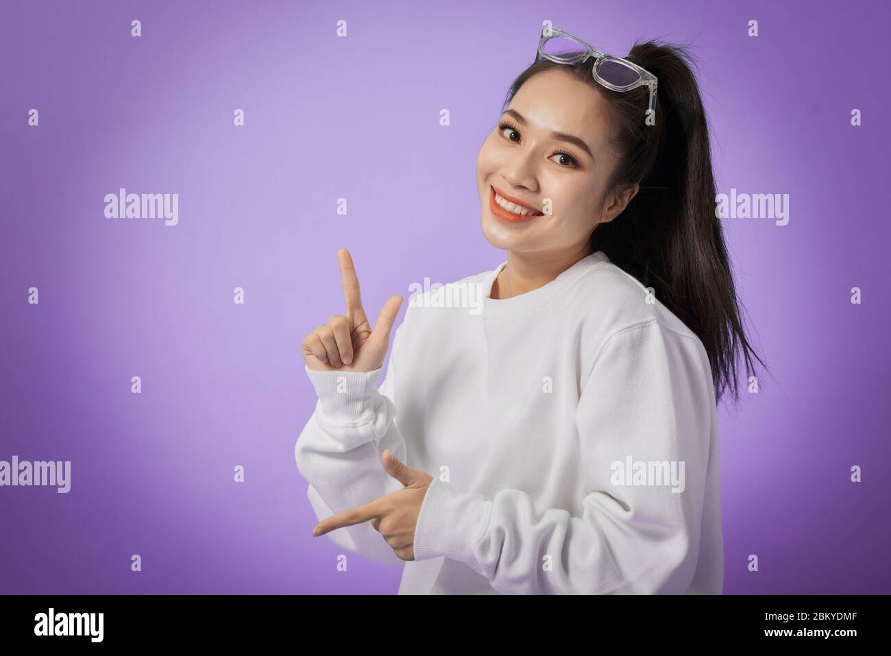 dancing beautiful woman showing both fingers in L-sign like fun guns ...