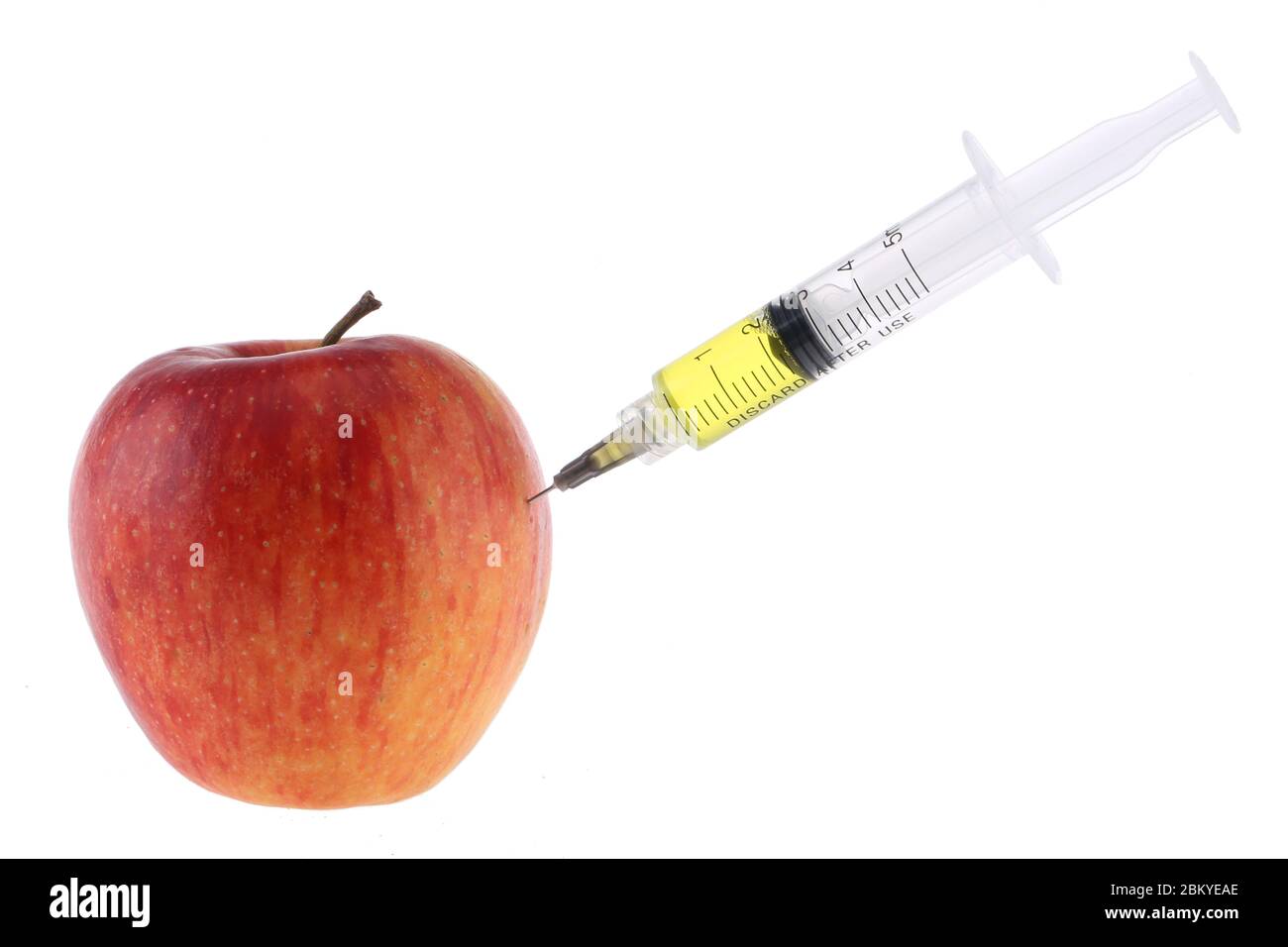 Injection into an apple. A hand in a medical glove with a syringe on a ...