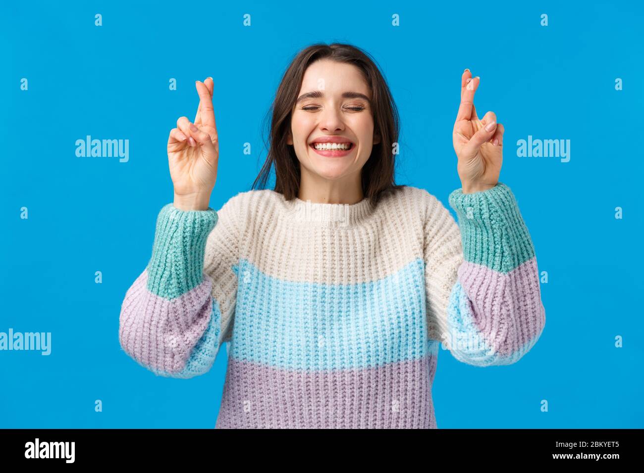 Optimistic cute feminine young girl in winter sweater, having faith ...