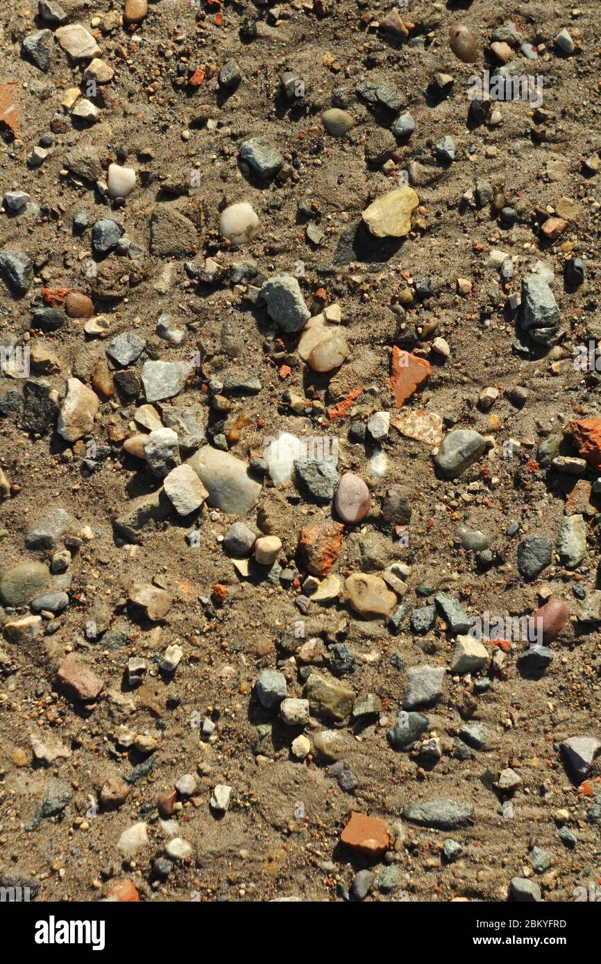Small stones and sand. The natural texture of the soil. Shore of a ...