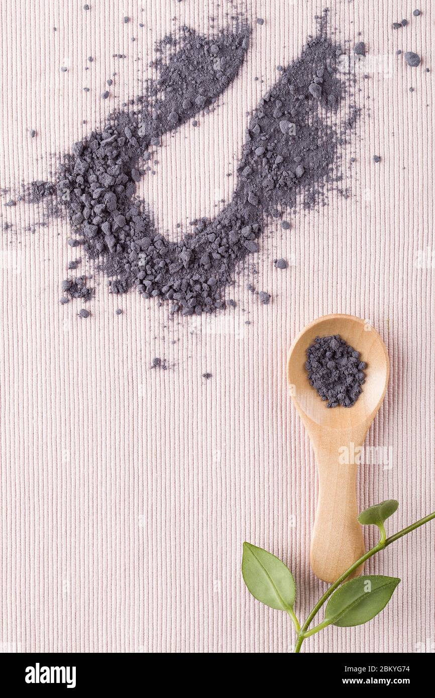 matcha blue tea powder in wood spoon on pink background with green ...