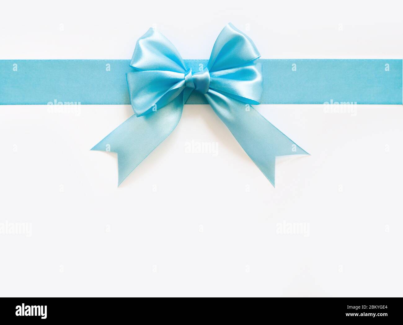 Blue wide satin ribbon with a bow. White background Stock Photo - Alamy