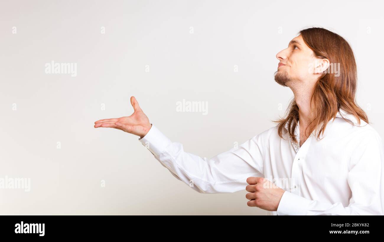 Masculinity playing concept. Young man making catching gesture. Long ...