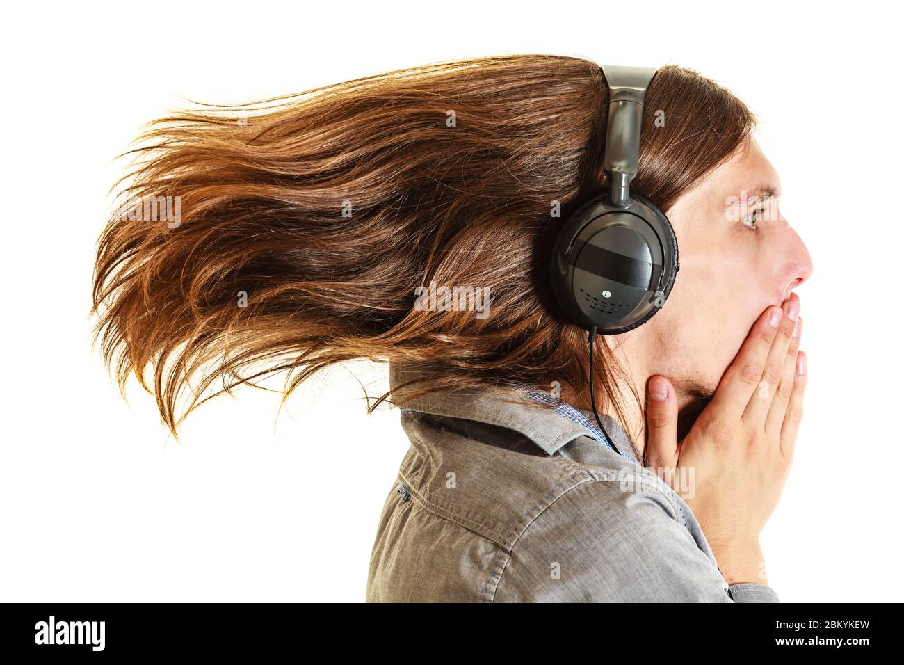Passionate music lover with long hair flying. Young man listening ...