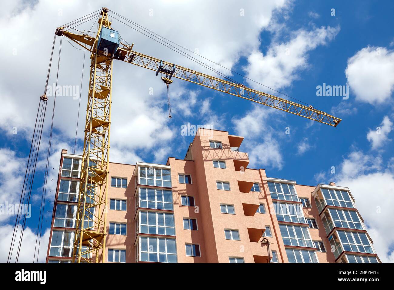 Tower crane building new modern apartment house on a background of blue ...