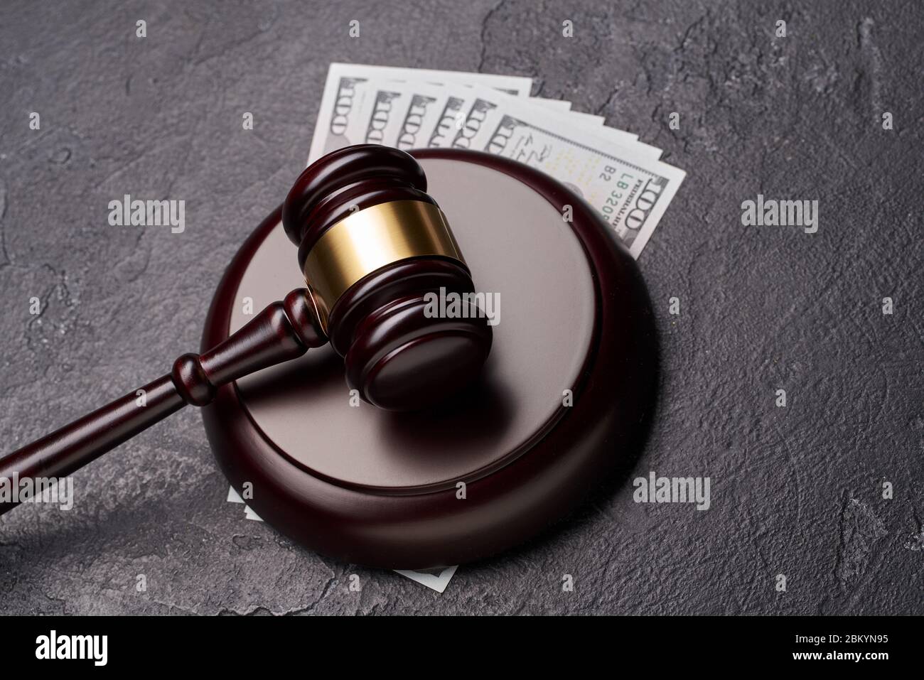 Symbol of court and justice, wooden gavel, dollars on black surface ...