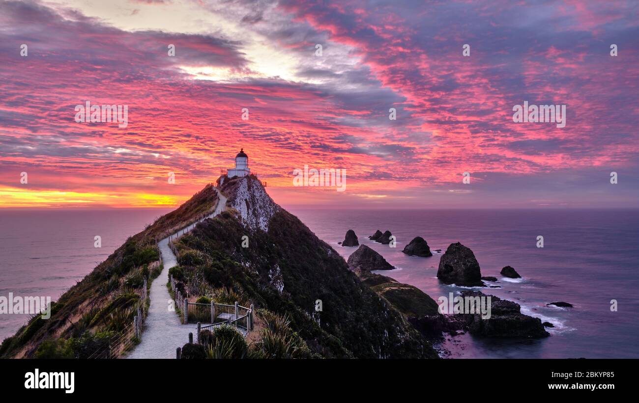 View of the Nugget point lighthouse at sunrise on a cloudy day and calm ...