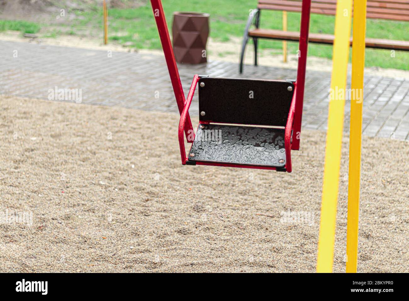 Empty swing at the playground in the rain. Children's swing in the park ...