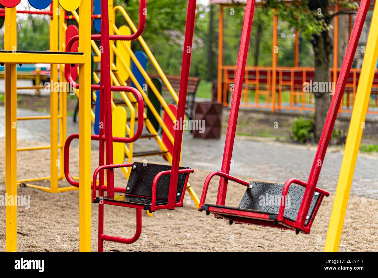 Empty swing at the playground in the rain. Children's swing in the park ...