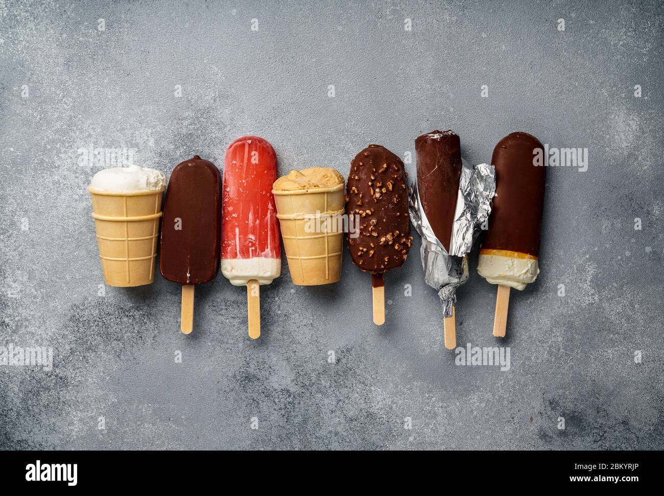 Chocolate ice cream popsicles and fruit ice cream with cones on gray ...
