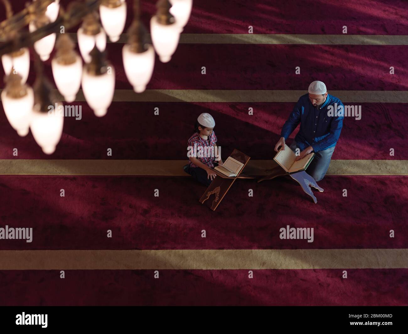 muslim prayer father and son in mosque praying and reading holly book ...