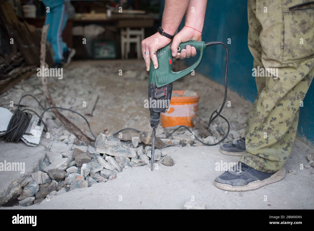 Man hammering the floor with a hand jackhammer Stock Photo - Alamy