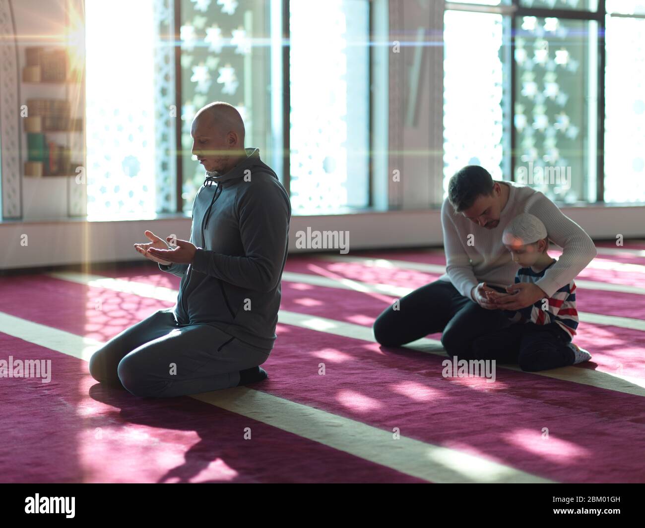 muslim prayer father and son in mosque praying and reading holly book ...
