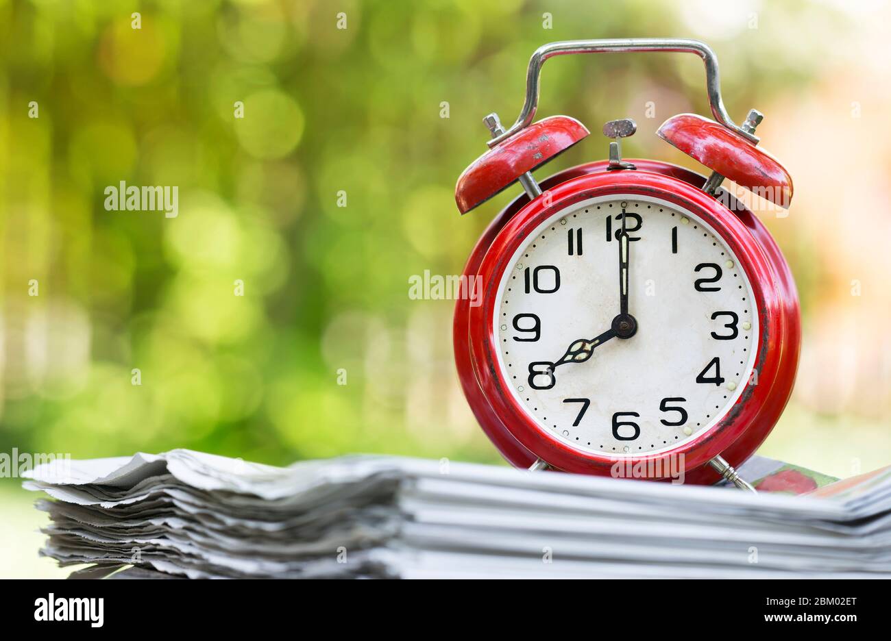 Morning news concept - newspaper and a red alarm clock with copy space ...