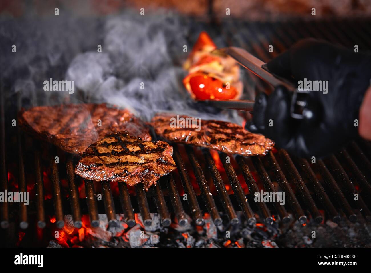 Fresh juicy grilled meat with fire. Barbecue concept, roasting meat on ...