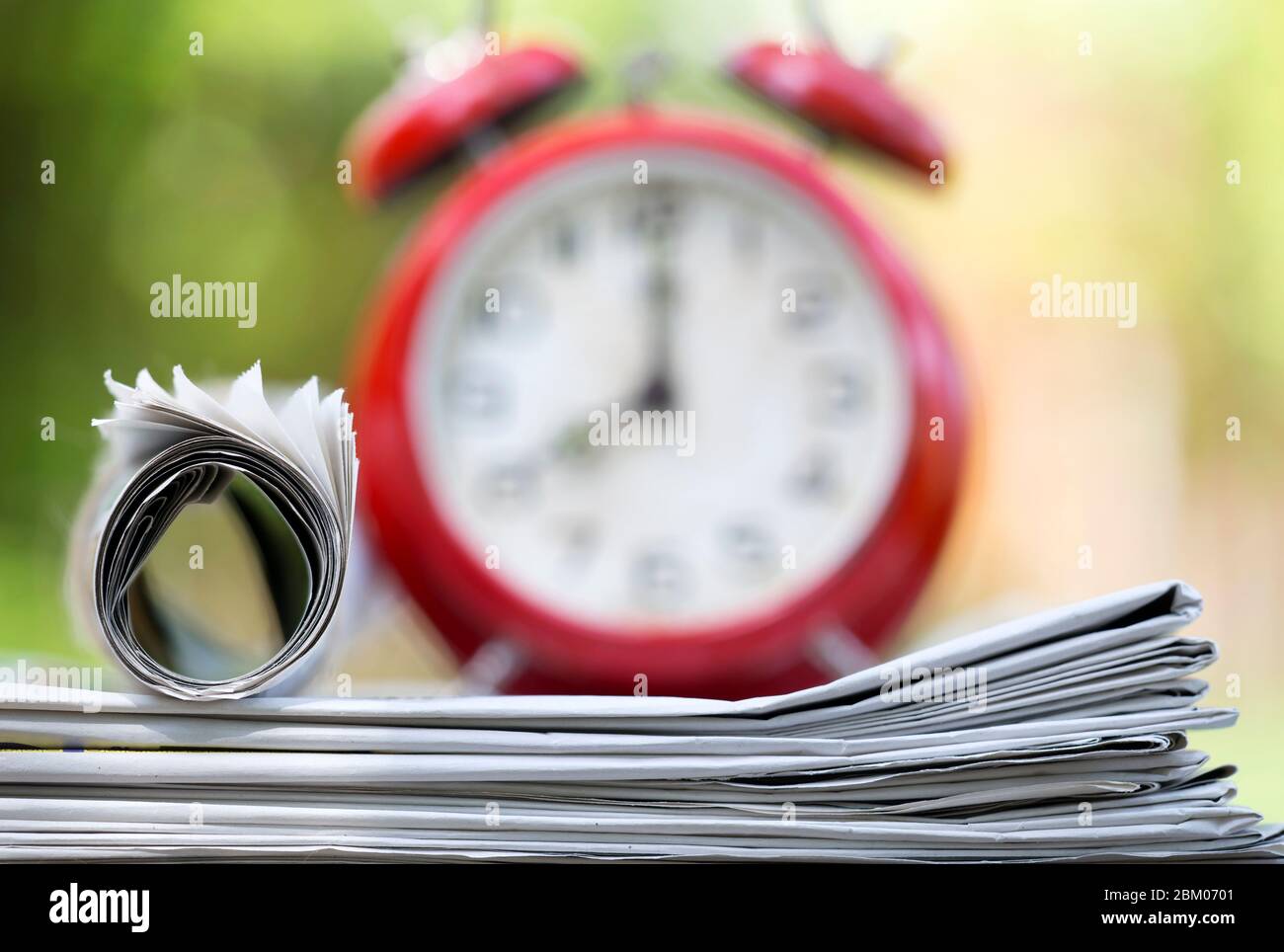 Daily news concept, newspaper with red alarm clock in the background ...