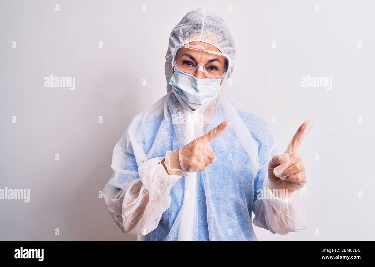 Middle age nurse woman wearing protection coronavirus equipment over ...