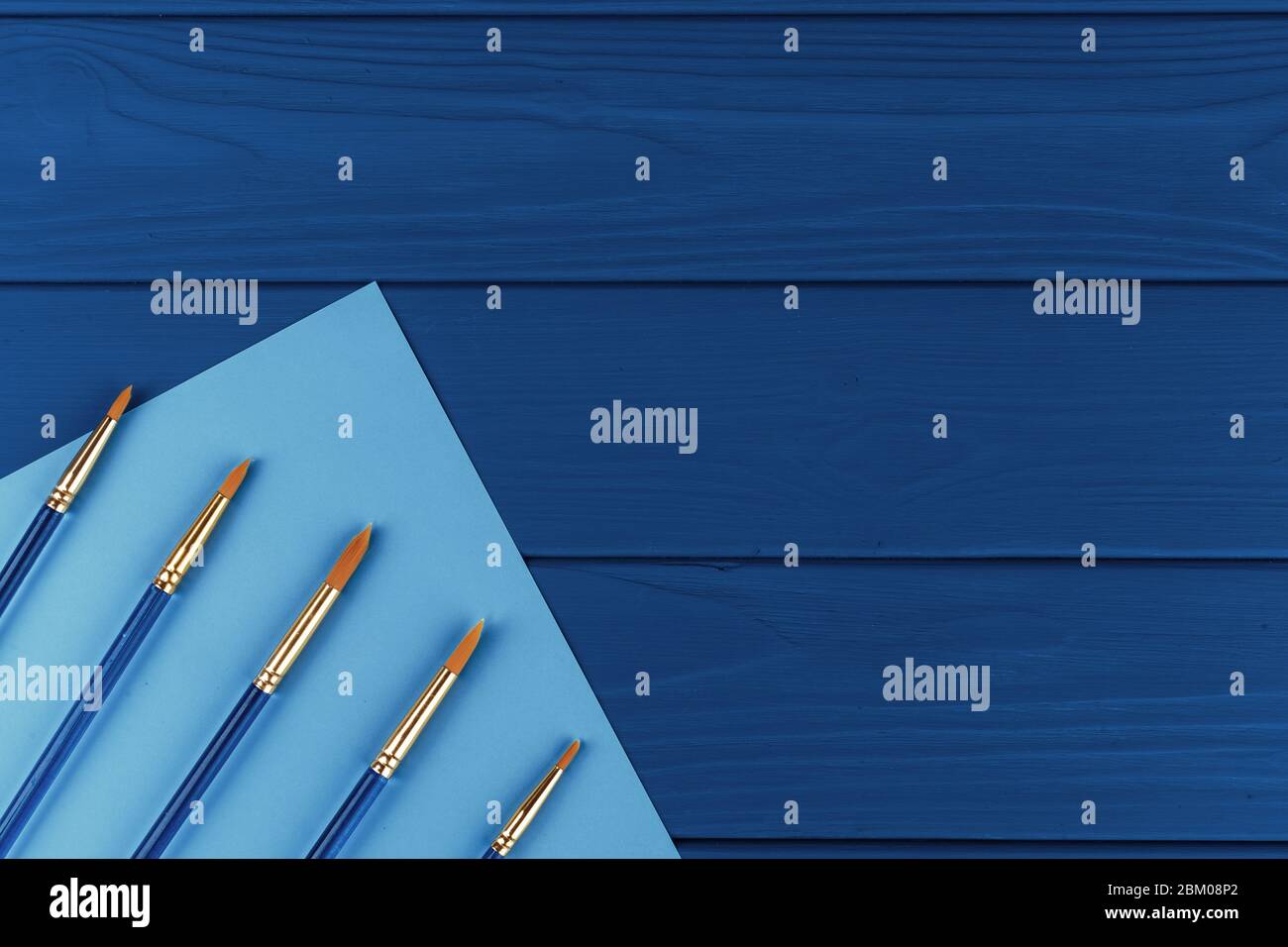 Blue paint brushes on classic blue background, view from above Stock ...