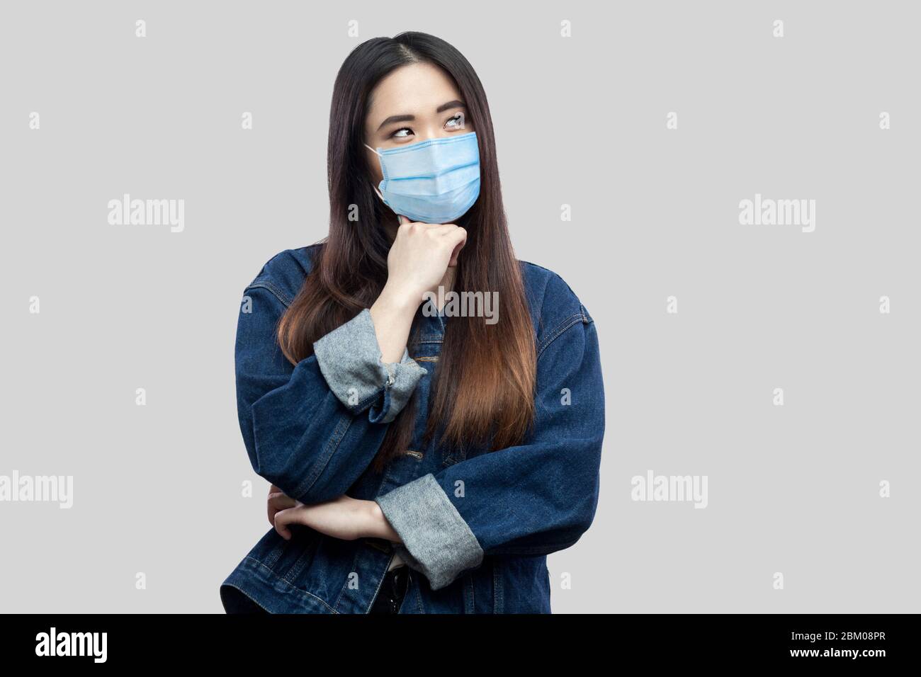 Portrait of thoughtful beautiful asian young woman with surgical ...