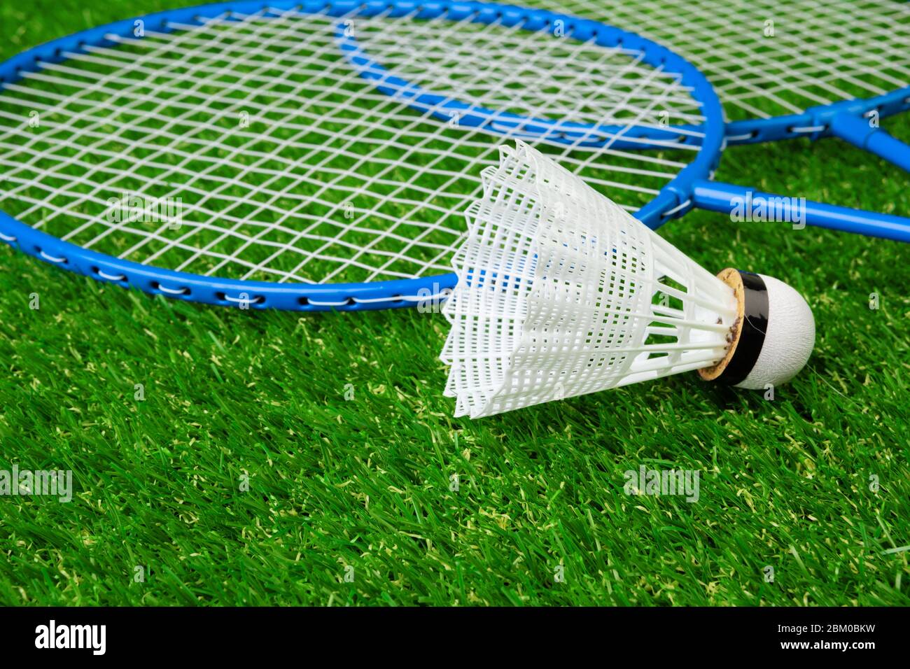 Badminton game rackets and shuttlecock on grass Stock Photo - Alamy