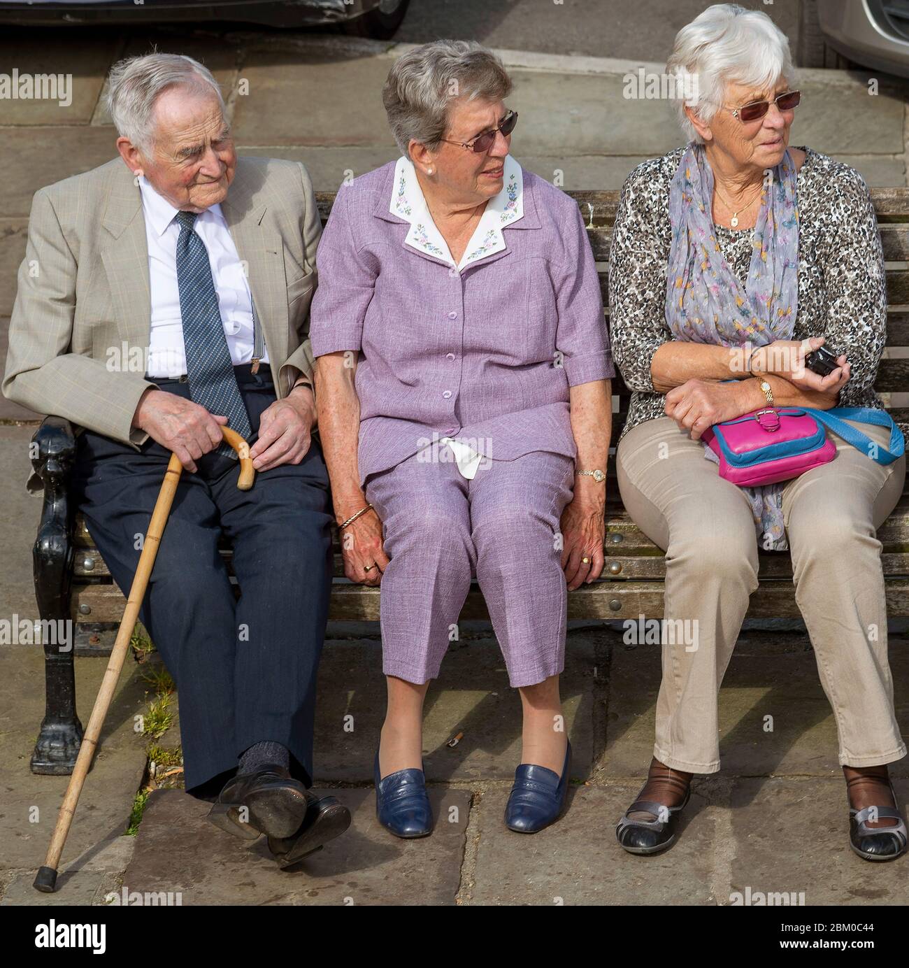 Wareham, Dorset, England, UK. circa 2014. Three elderly people sitting ...