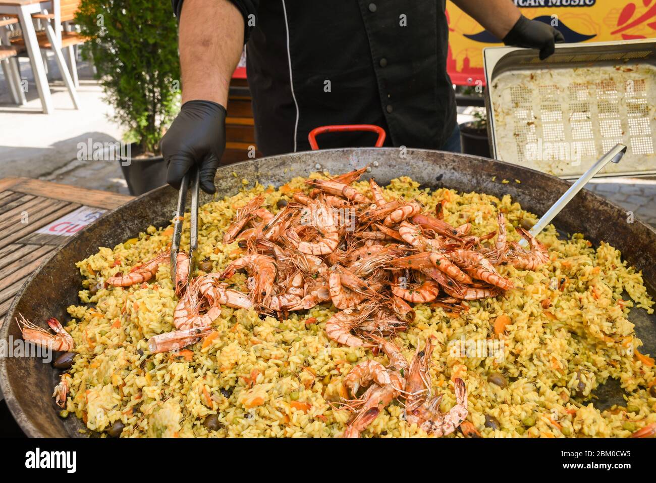 Seafood paella cooked in a large pan wok, street food festival. Mexican ...