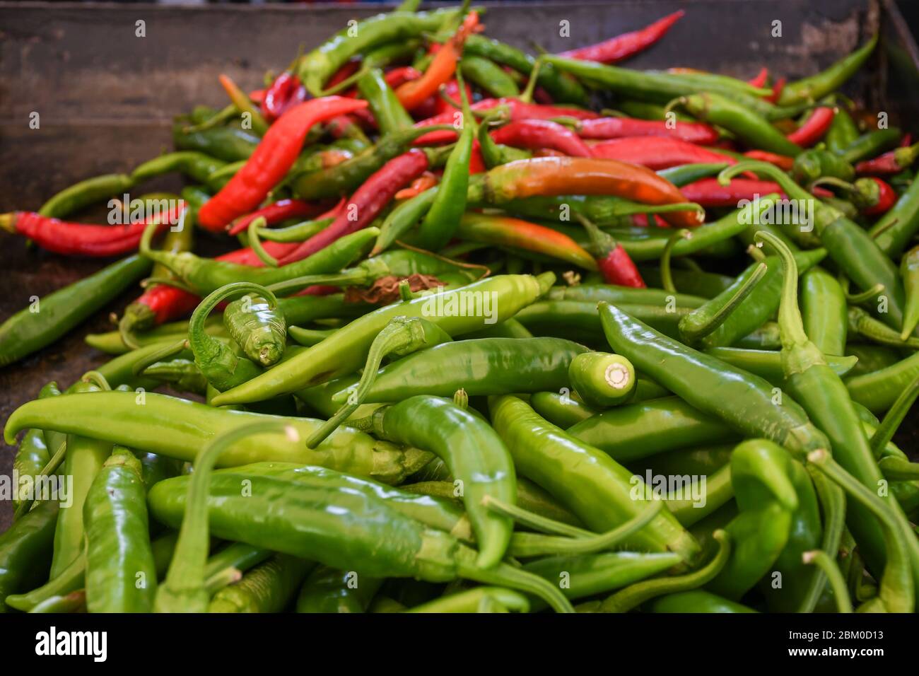 Green and red chili on a counter top of a store during food festival ...