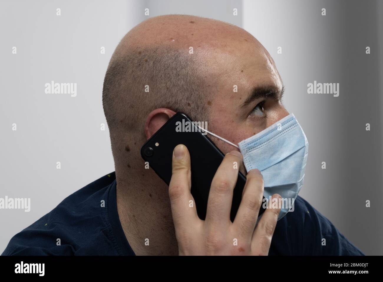 man in a mask talking on an isolated cell phone on a white background ...
