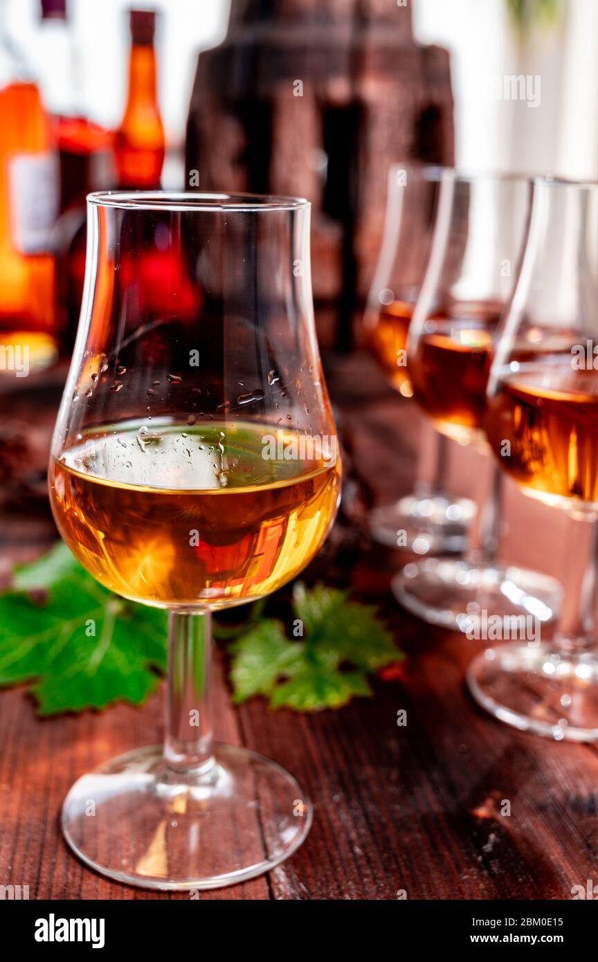 Tasting glasses with aged french cognac brandy in old cellars of cognac ...