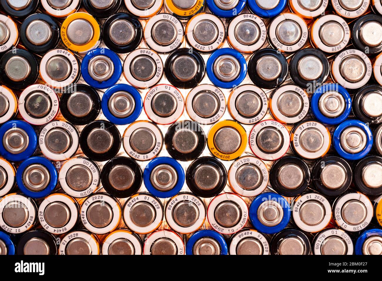 Multiple used AA alkaline batteries are seen arranged in a pile ...