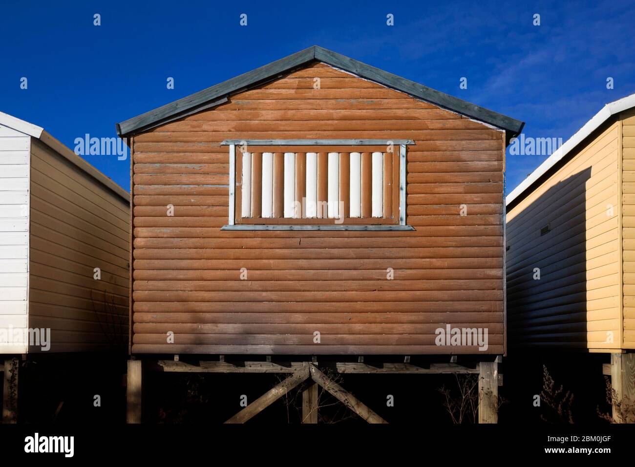 Brown wood panel weatherboard beach hut from the rear at the beach in ...