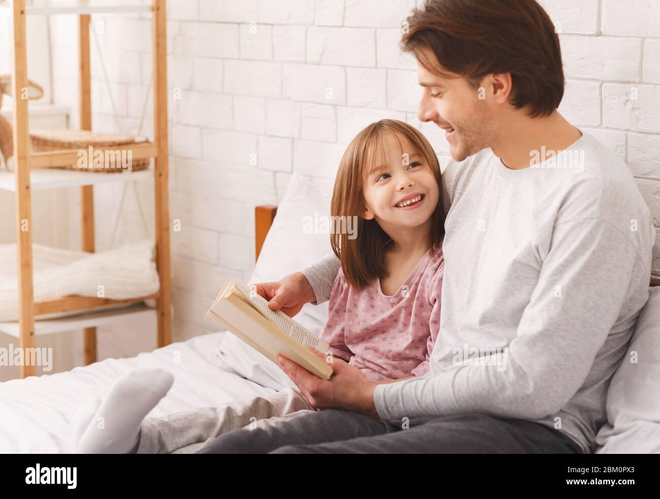 Loving father reading fairy tales to his little daughter Stock Photo ...