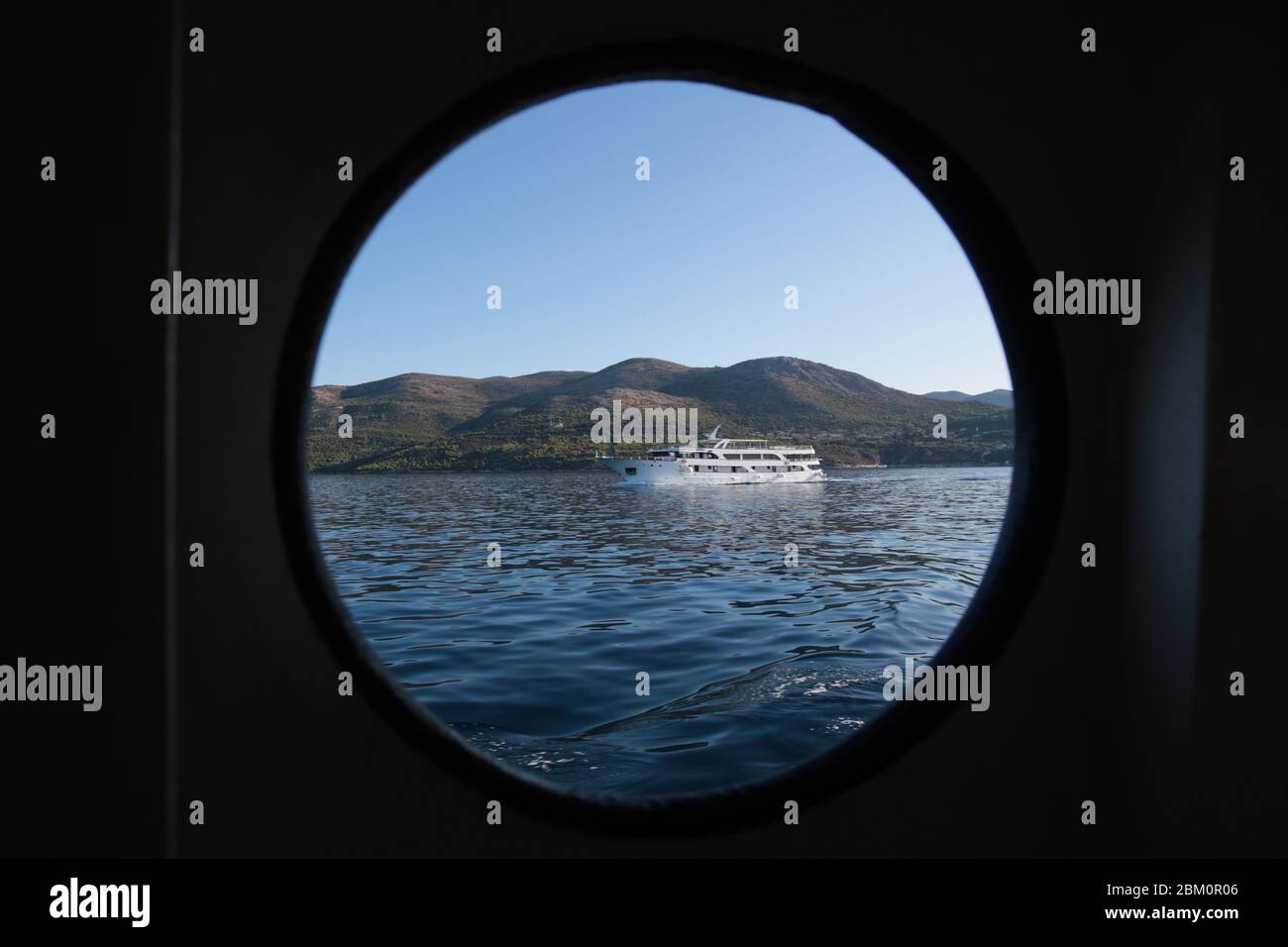A tourist ship sailing photographed through a silhouette of a ships ...