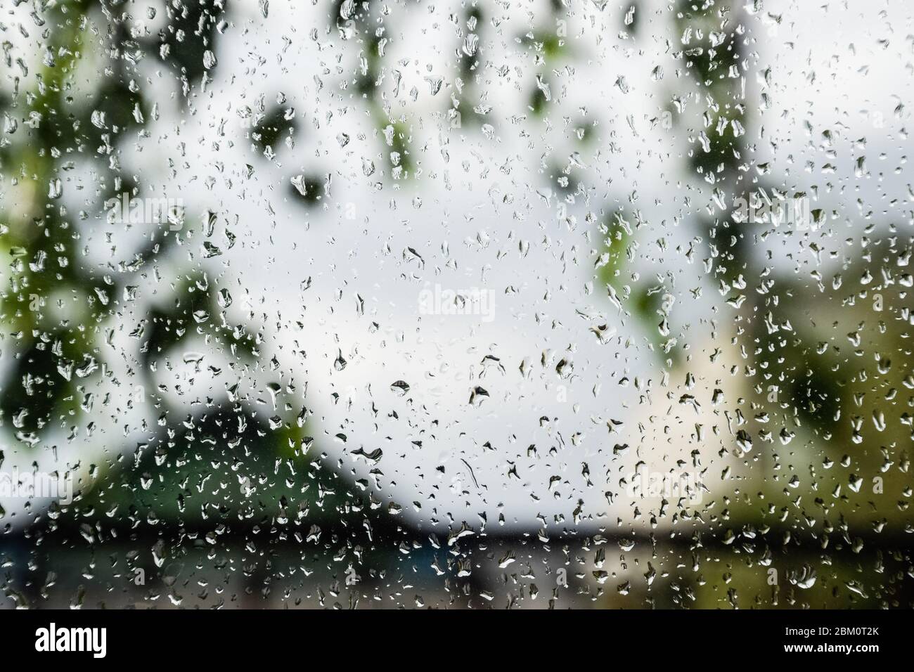 Raindrops on the window pane. Blurred background outside the window in the rain Stock Photo - Alamy