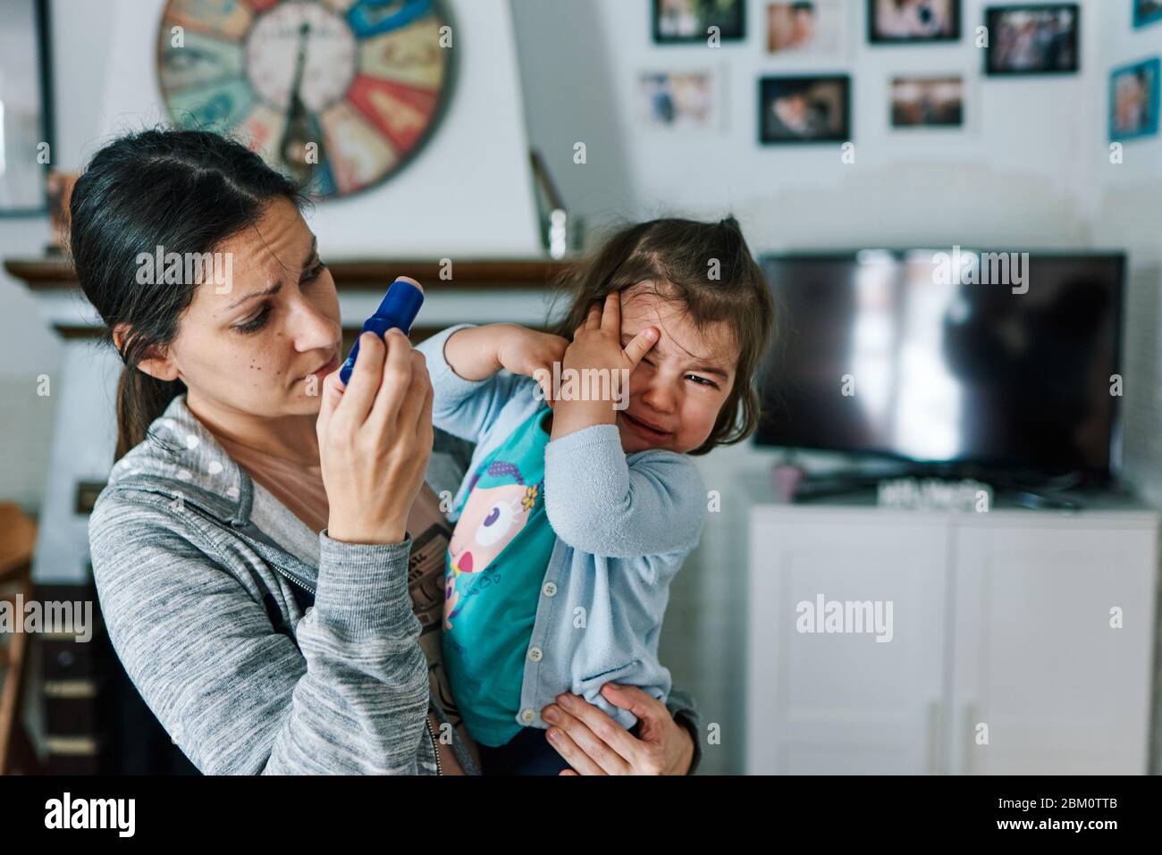 brunette woman with child crying in her arms Stock Photo - Alamy