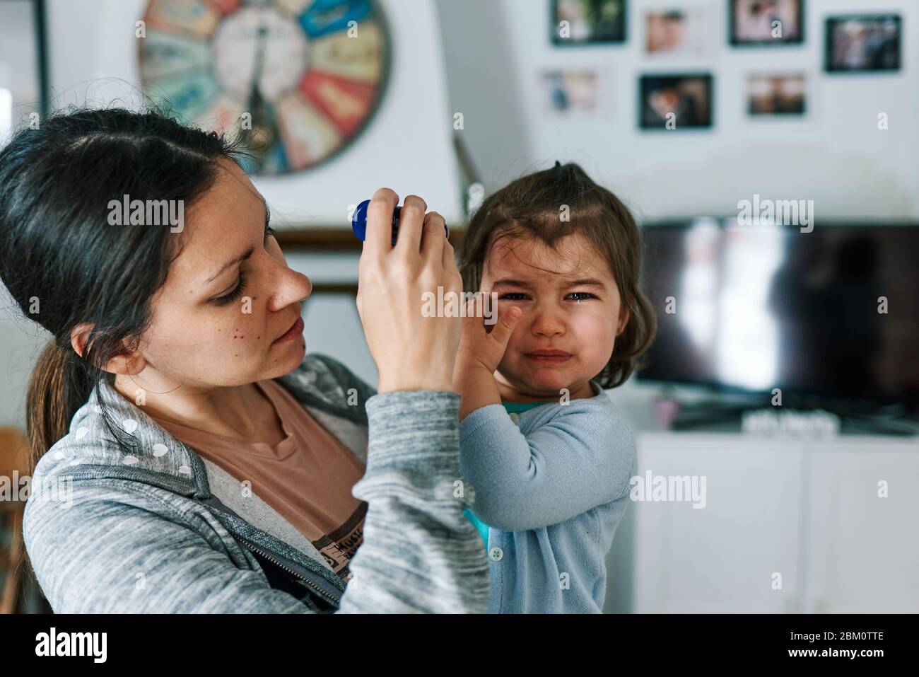 brunette woman with child crying in her arms Stock Photo - Alamy