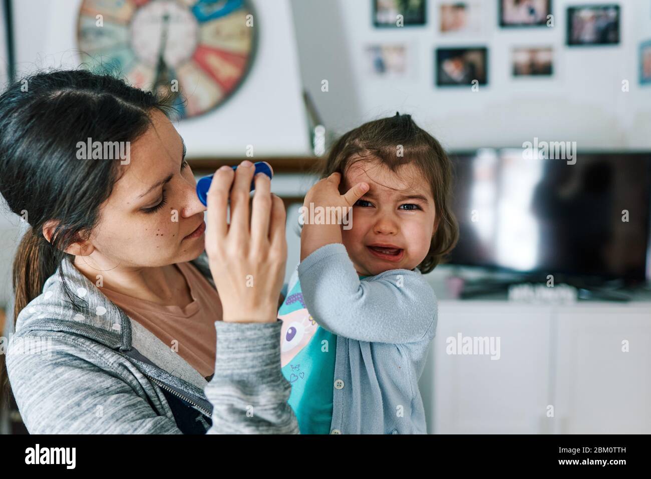 brunette woman with child crying in her arms Stock Photo - Alamy