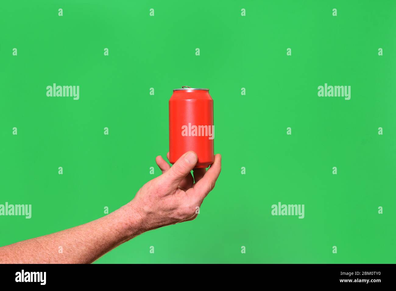 man holding a can on green background Stock Photo - Alamy