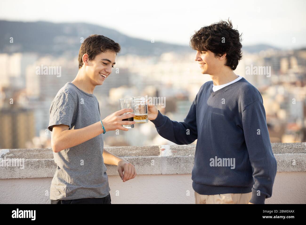 Two young men making a toast outdoors Stock Photo - Alamy
