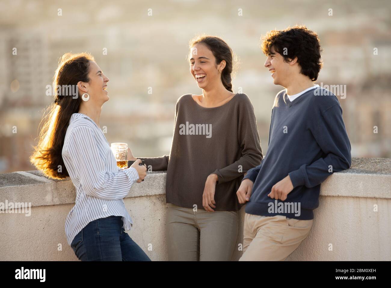 Three brothers talking and laughing on the rooftop Stock Photo - Alamy