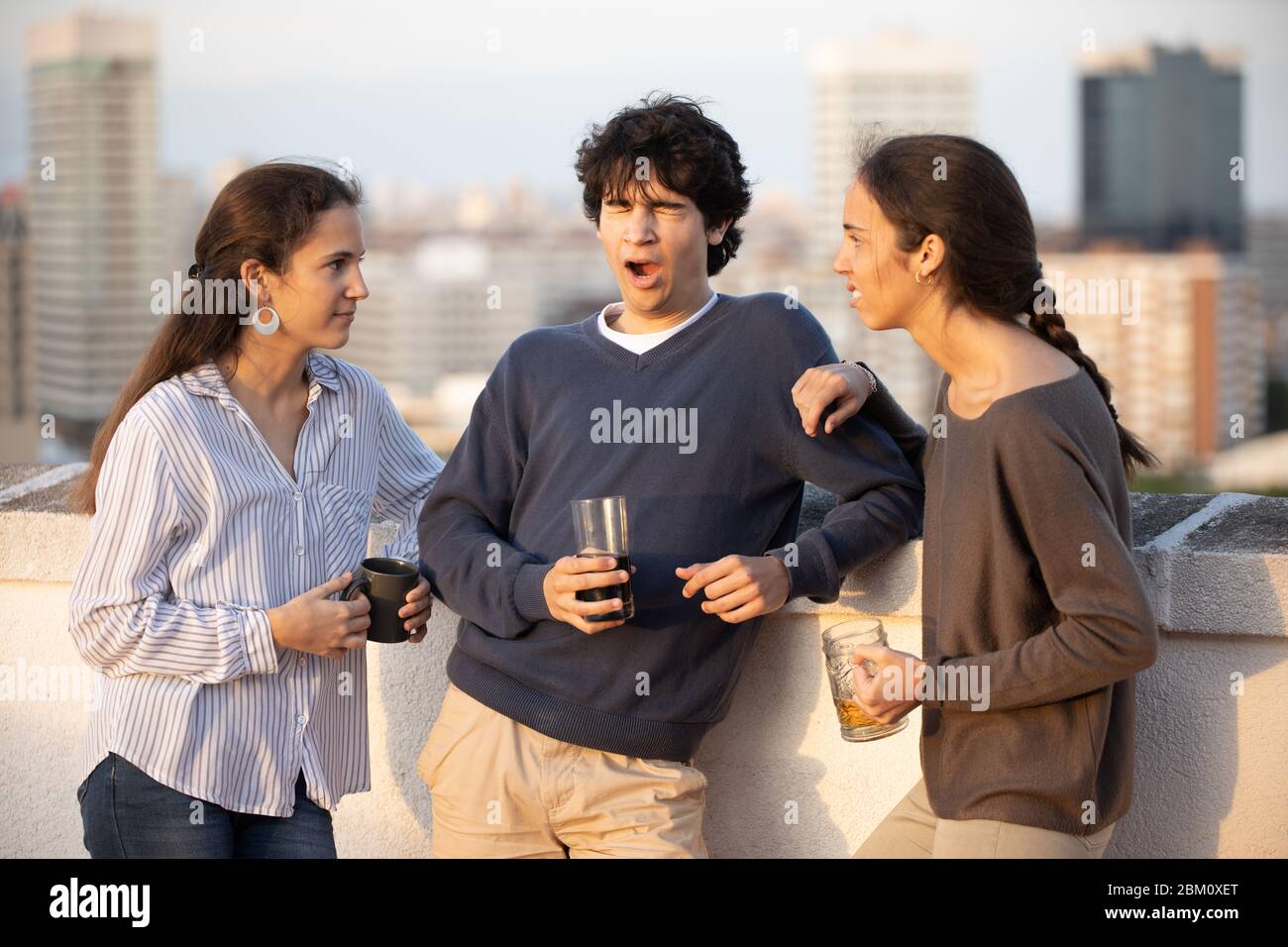 Two girls complaining about their brother who is yawning Stock Photo ...