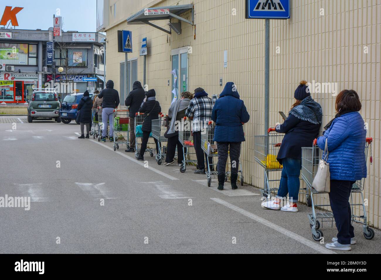 Long line of people waiting with shopping carts to do grocery. Daily ...