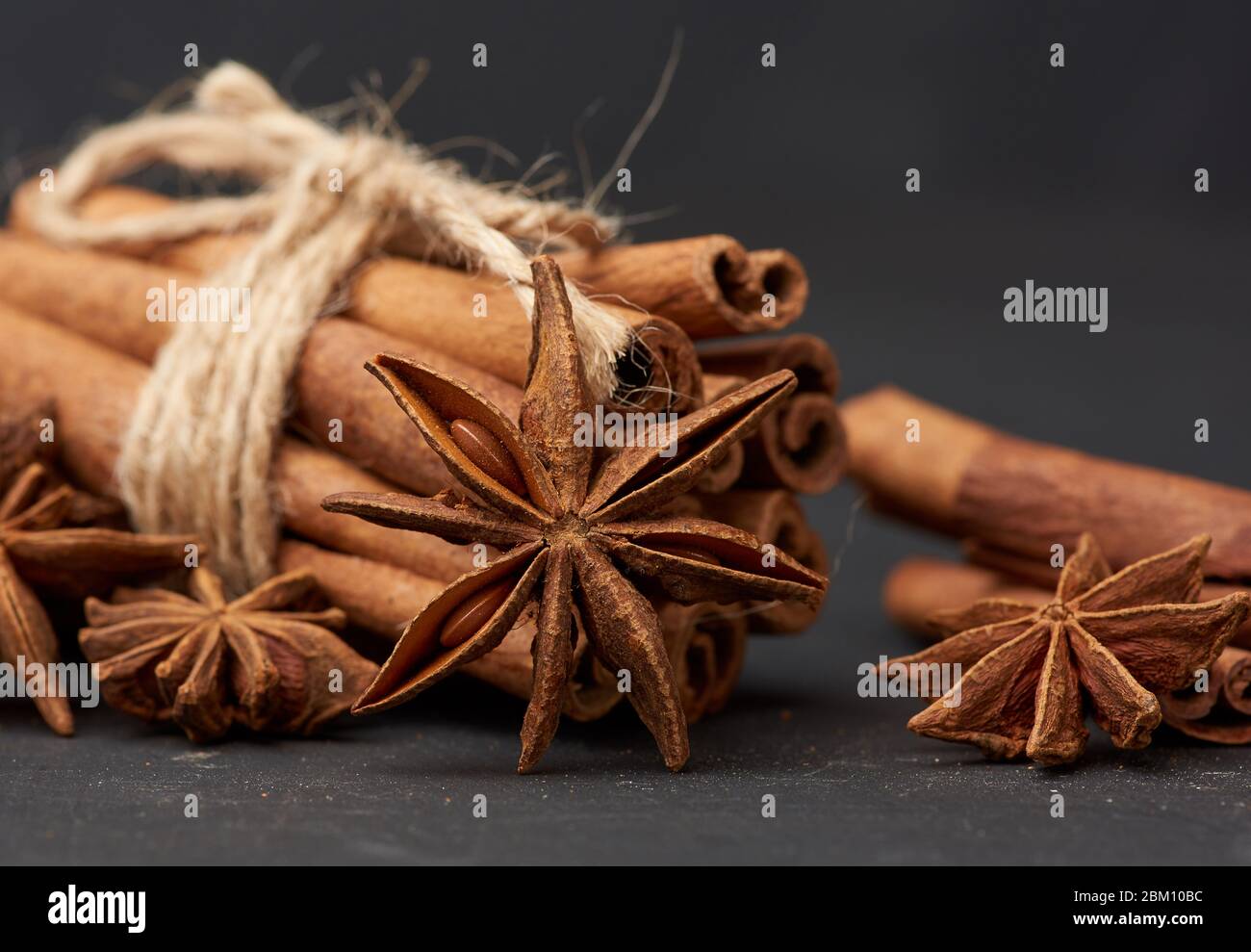 dry star anise with a bunch of brown cinnamon sticks tied with a rope ...