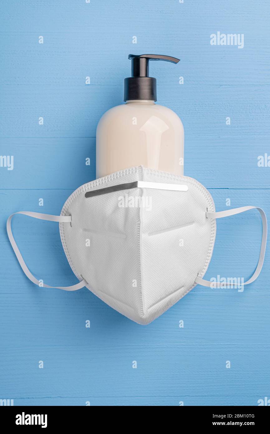 white n95 respiratory mask covers a plastic container with mild soap ...