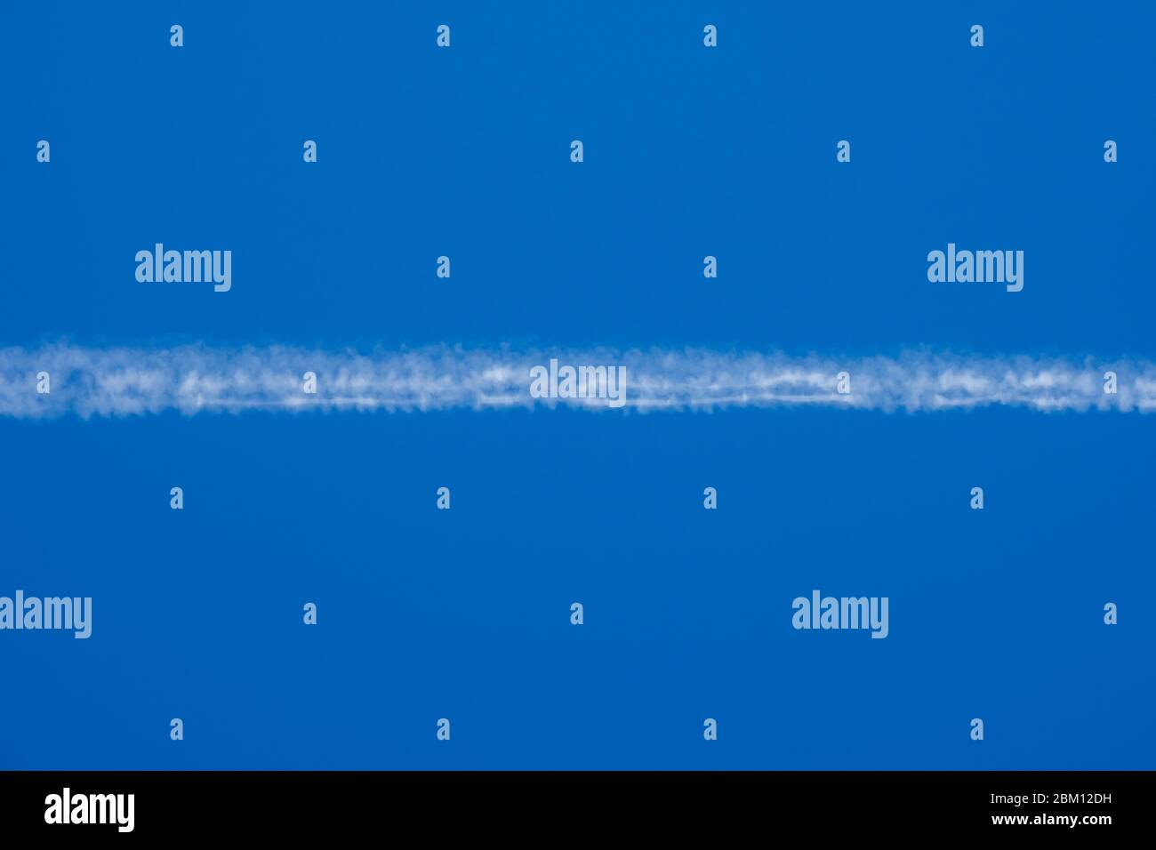 White condensation trail from an airplane flying at high altitude in a ...